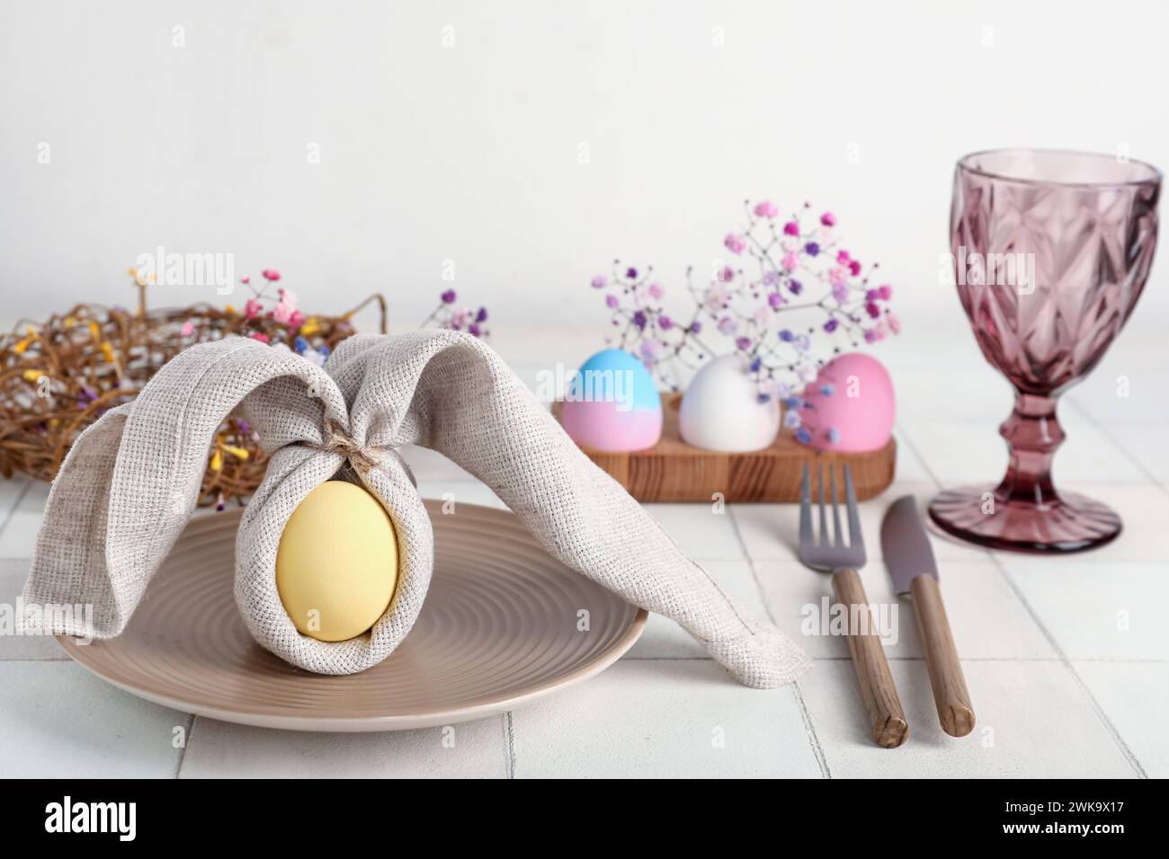 Beautiful serving for Easter with eggs, wreath and flowers on white ...