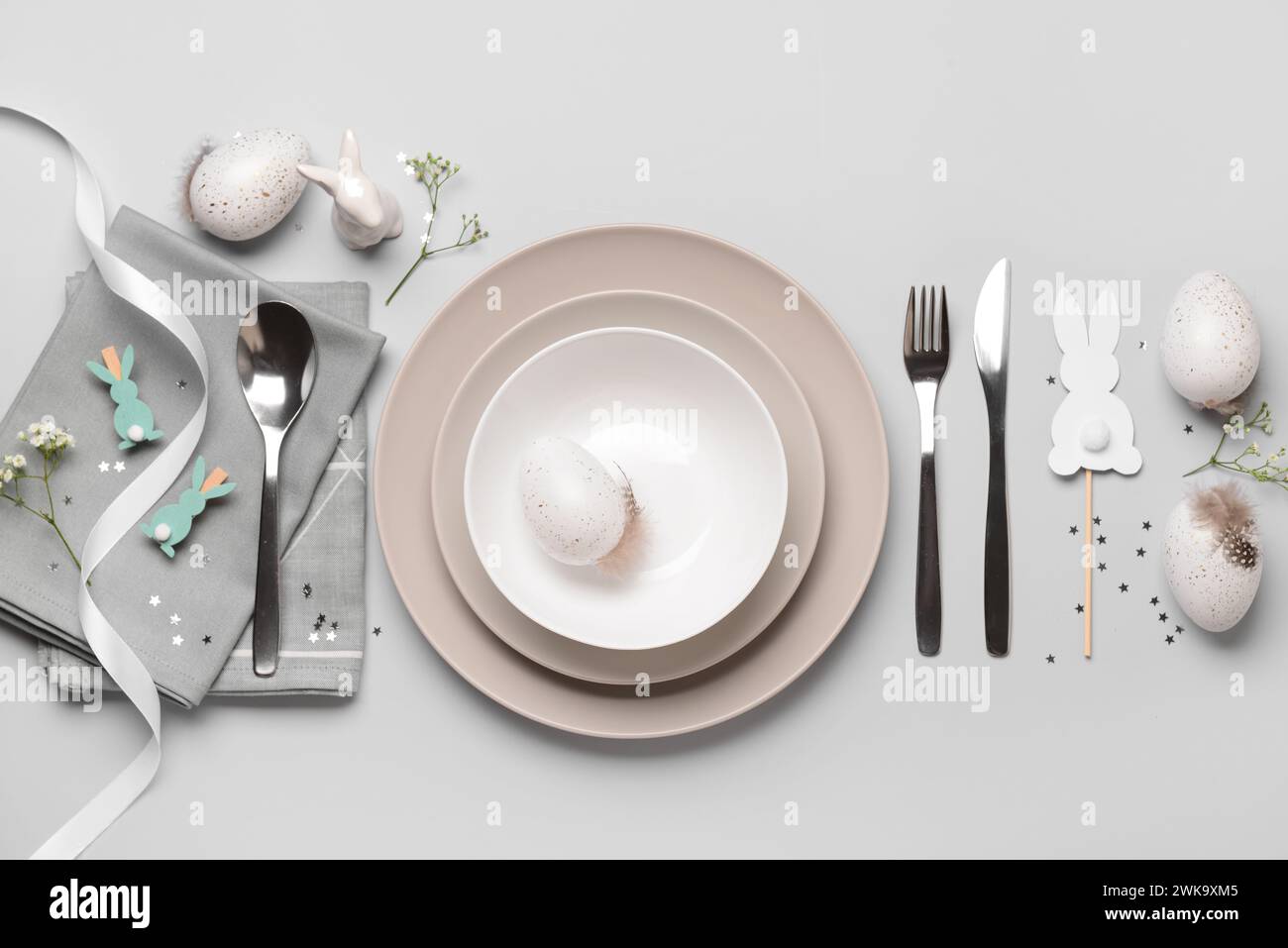 Modern Easter table setting with eggs and bunnies on white background ...