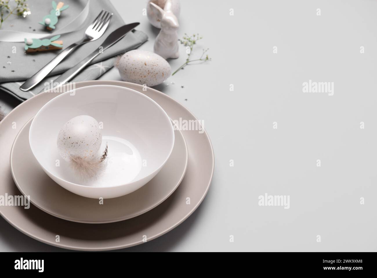 Modern Easter table setting with eggs and bunnies on white background ...