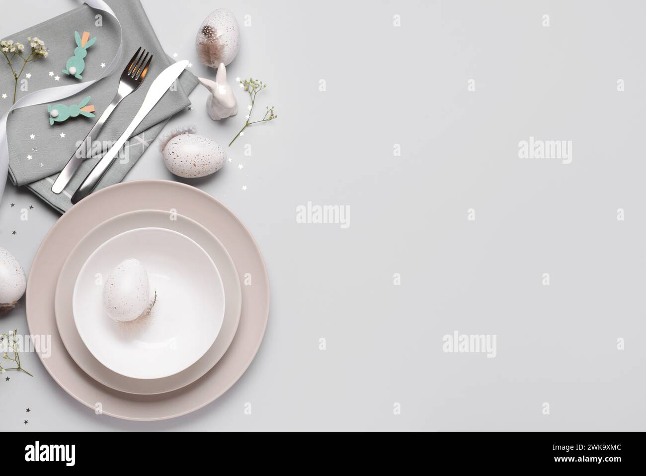 Modern Easter table setting with eggs and bunnies on white background ...