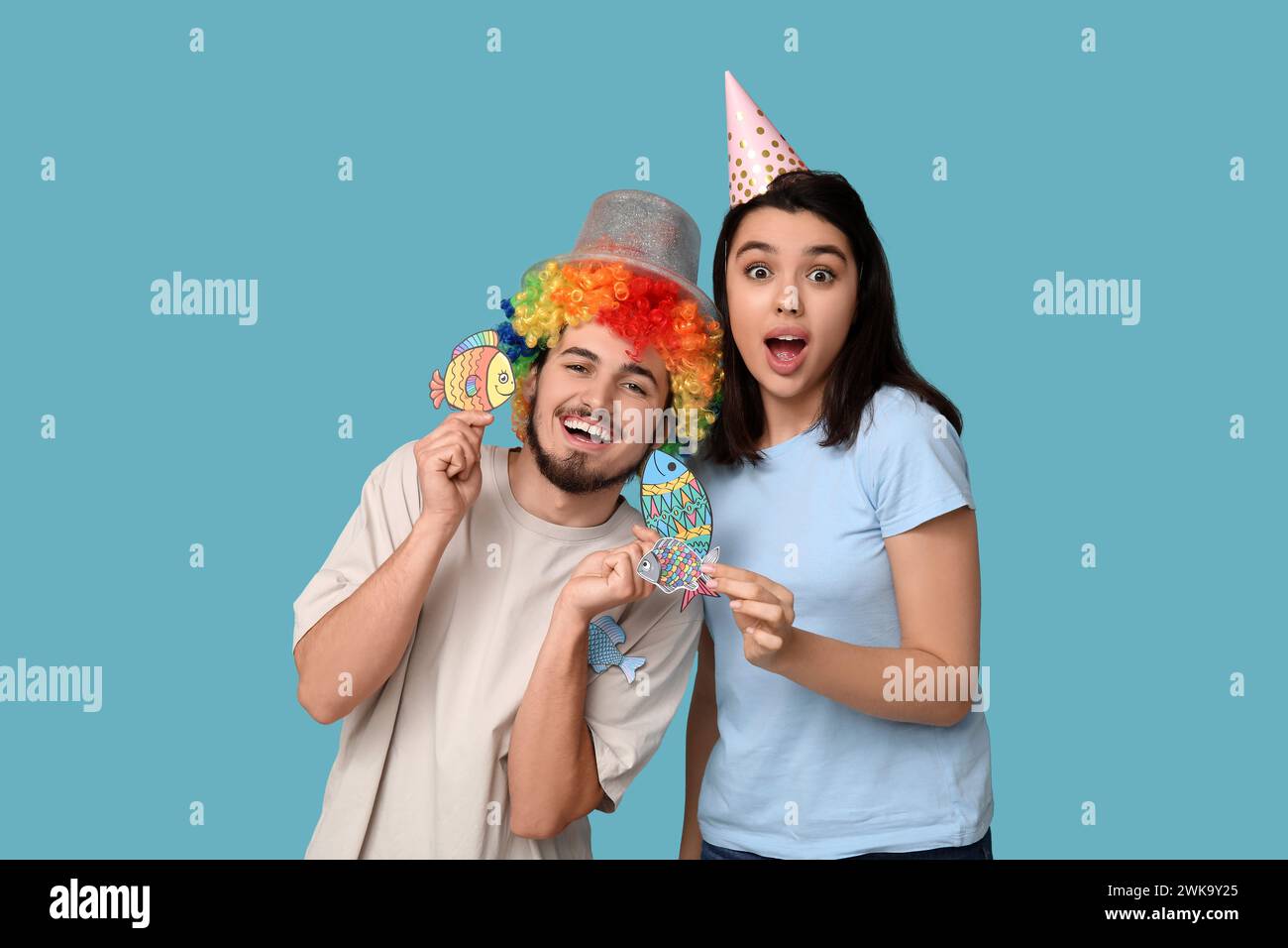 Young shocked friends in funny disguise with paper fishes on blue ...