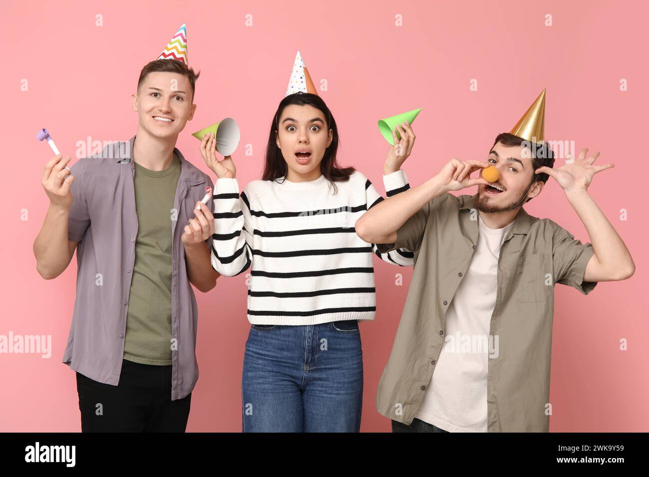 Young shocked friends in funny disguise with party cones and whistles ...