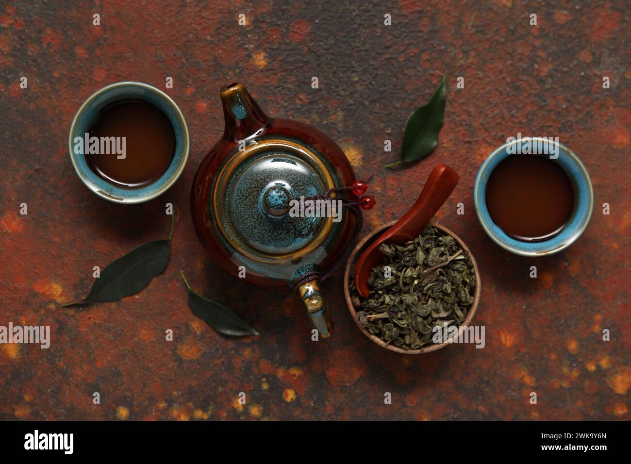 Cups of aromatic puer tea with hot teapot on brown background Stock ...