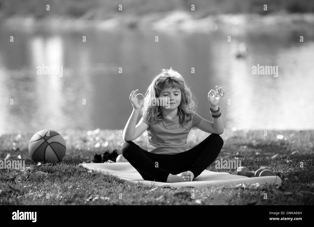 Little child sitting on the roll mat practicing meditate yoga in the ...