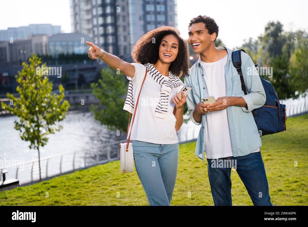 Photo of young girlfriend pointing finger far away in urban atmosphere ...