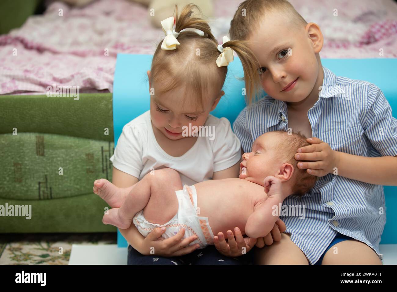 Little brother and sister rejoice at the newborn baby. Three children ...