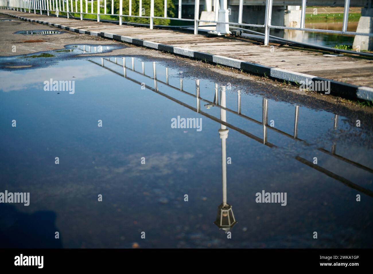The reflection of old fashioned street lamp post in rain puddle on an ...