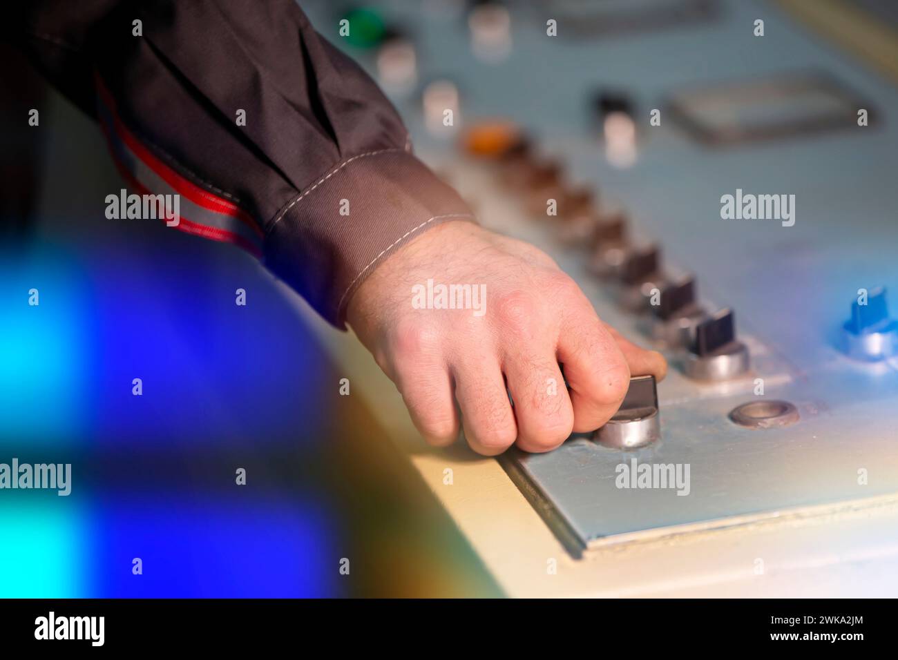 A worker's hand turns the starting switch to start production Stock ...