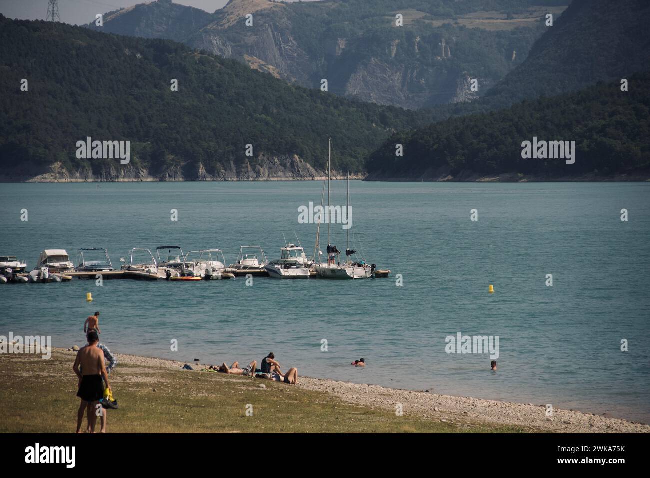 Lake in France with mountains in the background, blue water and boats ...