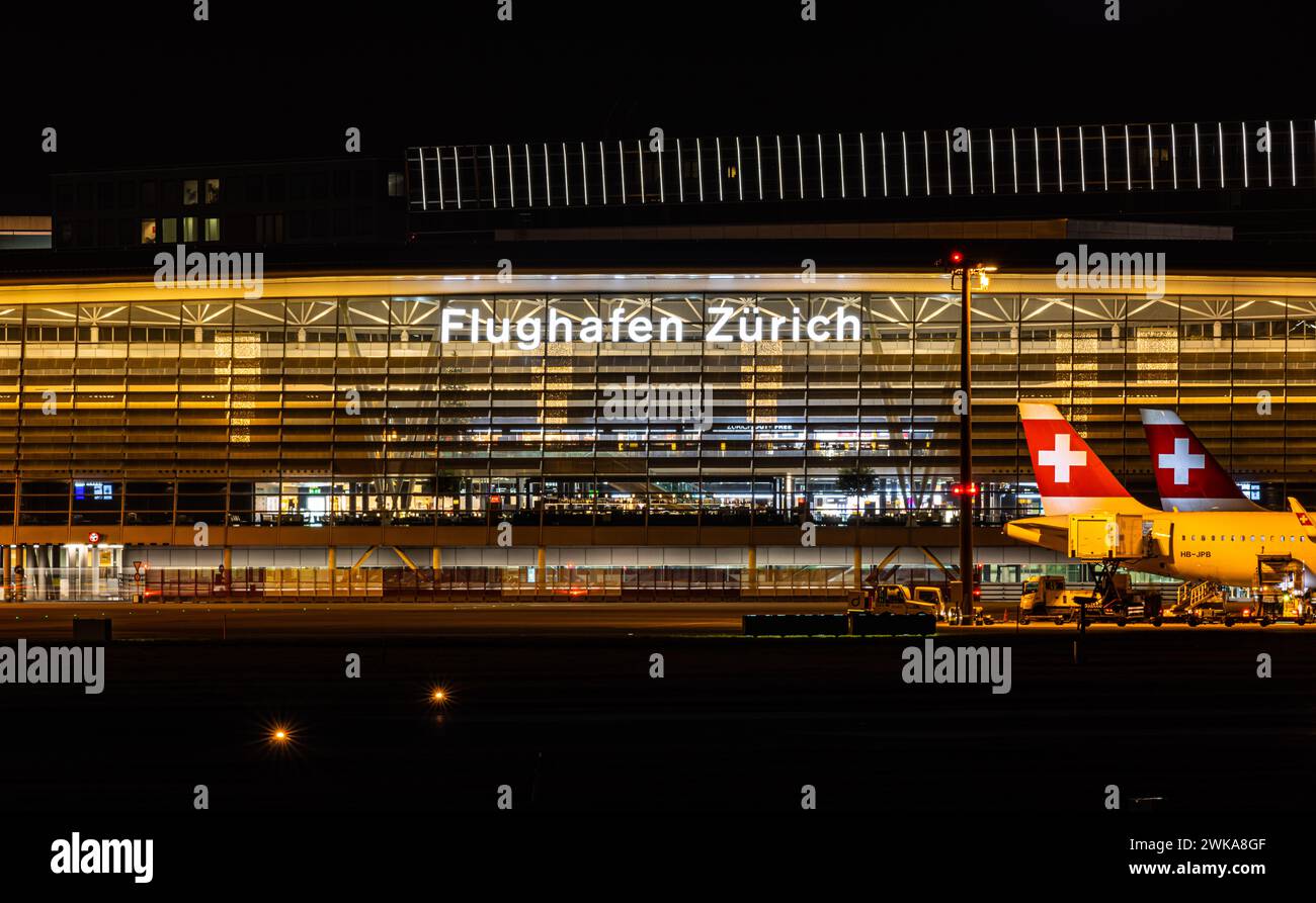 Der Flughafen Zürich bei Nacht. Zusehen sind Heckflossen von Flugzeugen ...