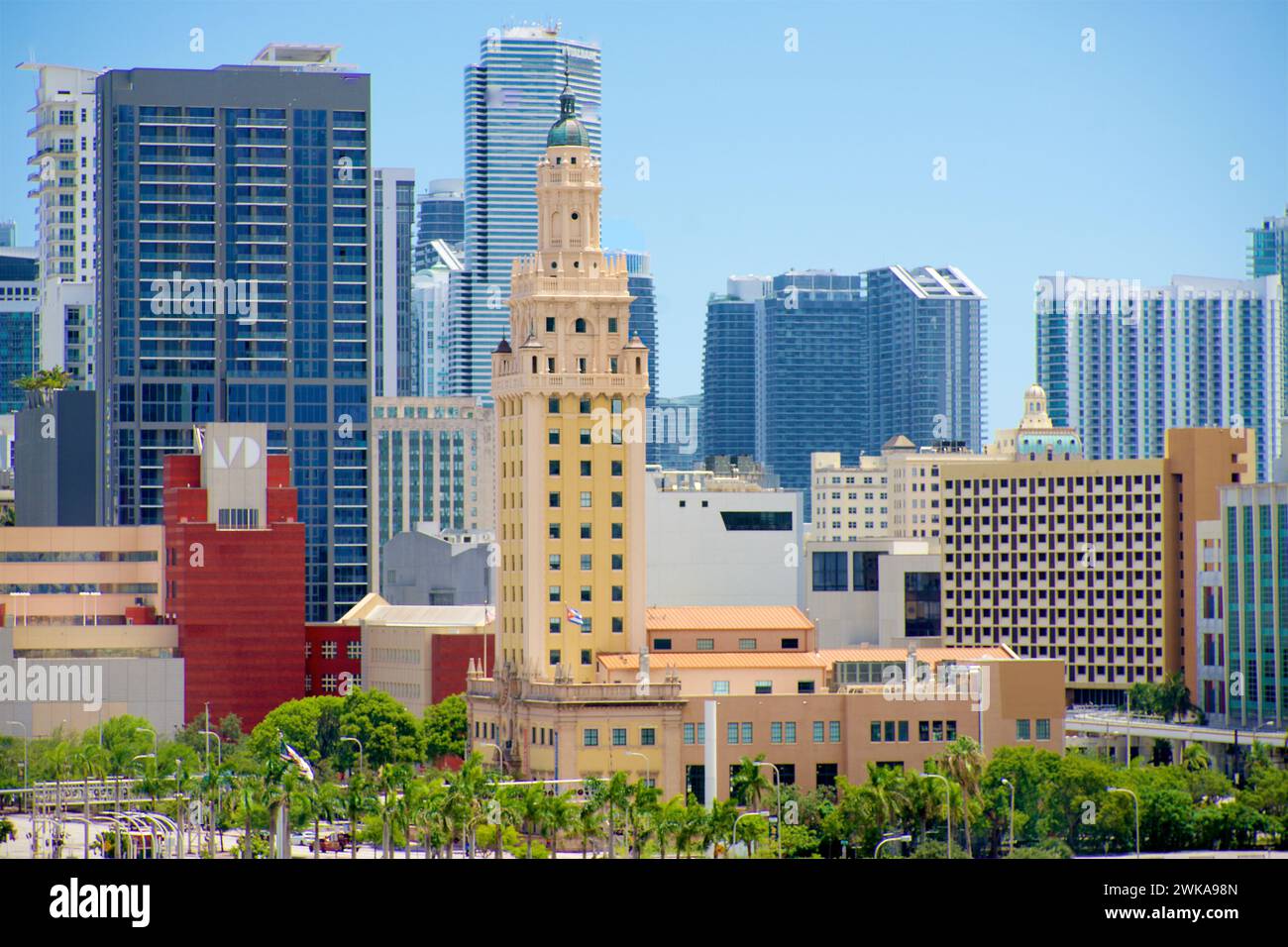 A cityscape with a clock tower, waterfront, and skyscrapers in Miami ...