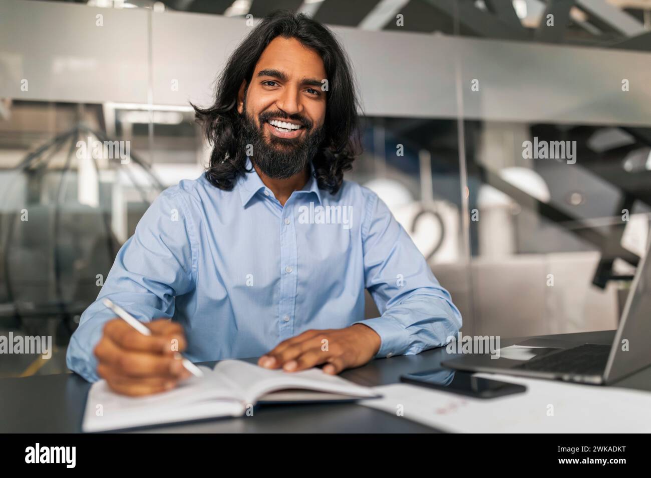 Positive young indian man employee working at office Stock Photo - Alamy