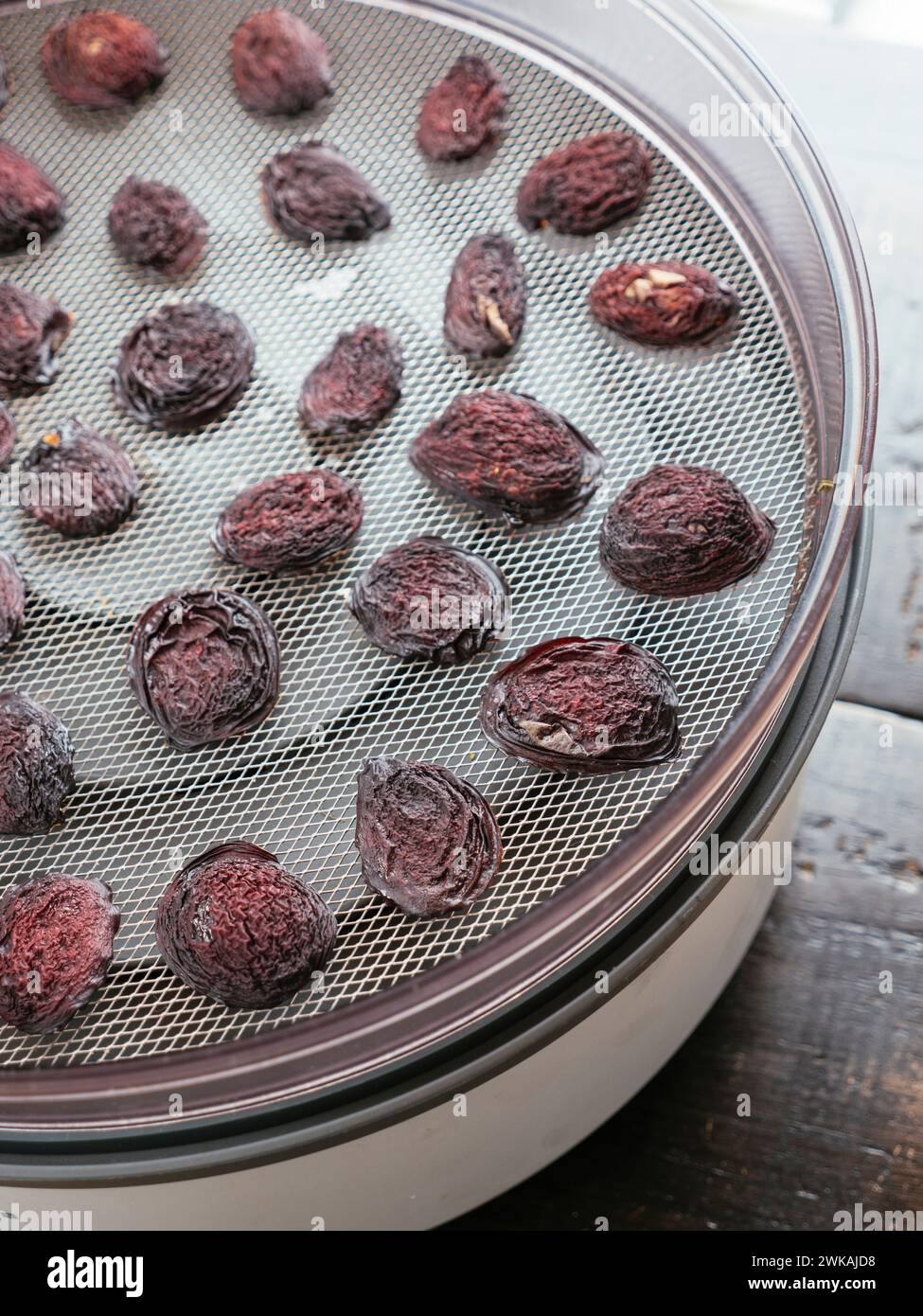Home made prunes on the rack of a dehydrator Stock Photo - Alamy