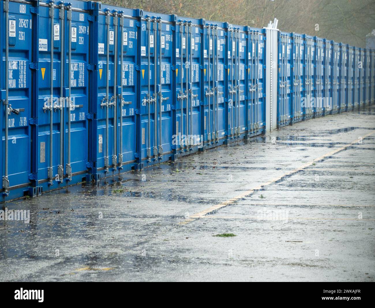 A line of blue shipping containers used as storage units photographed ...