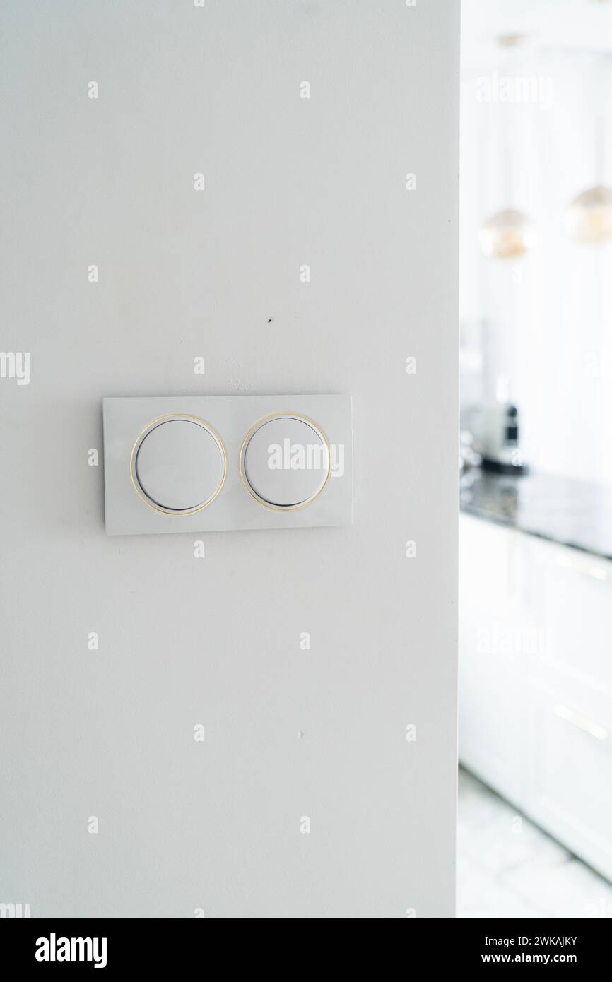 double electric light switch on white concrete wall Stock Photo - Alamy