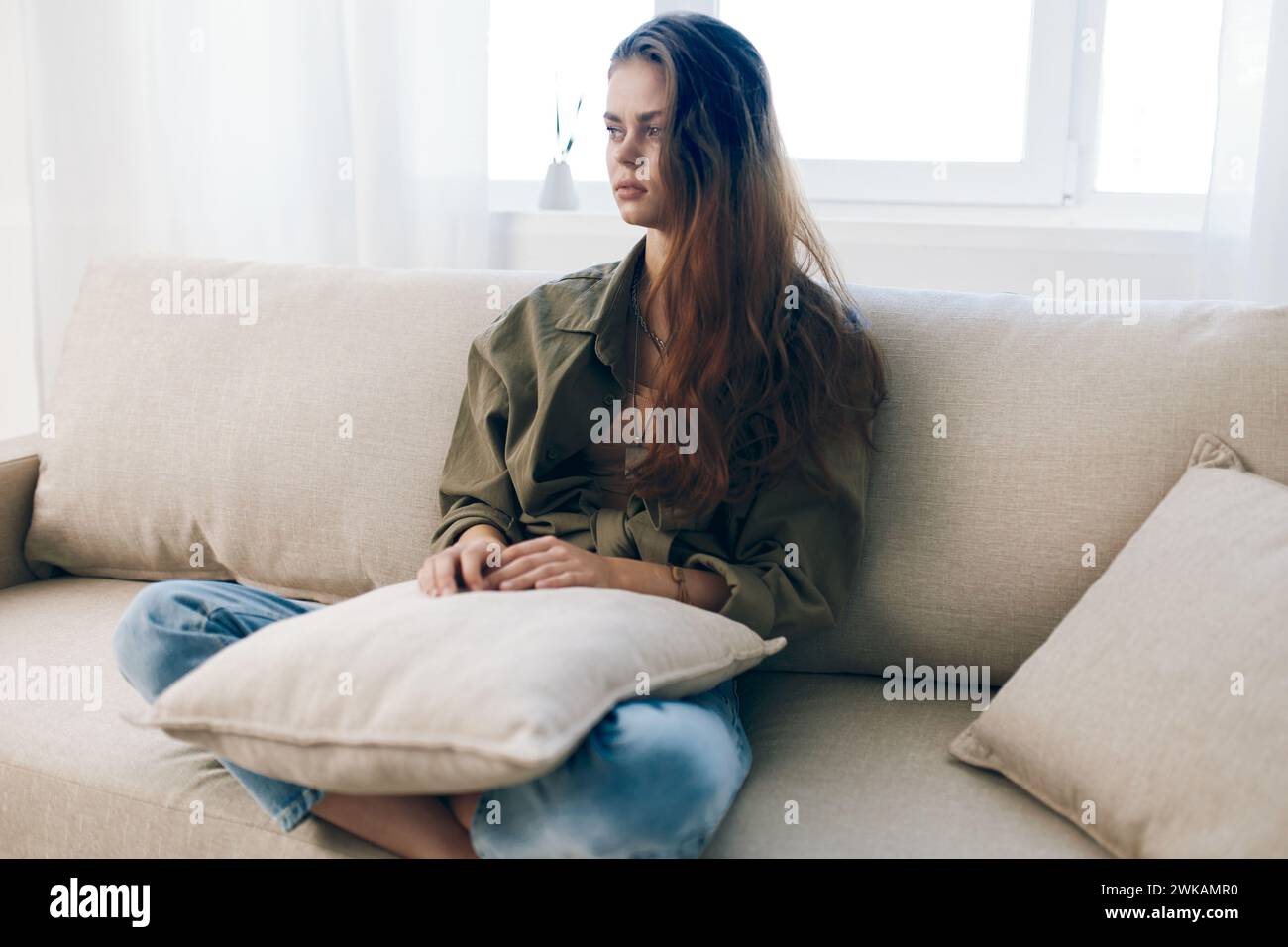 Worried Woman Sitting on a Couch, Feeling Sad and Stressed - Depicting ...