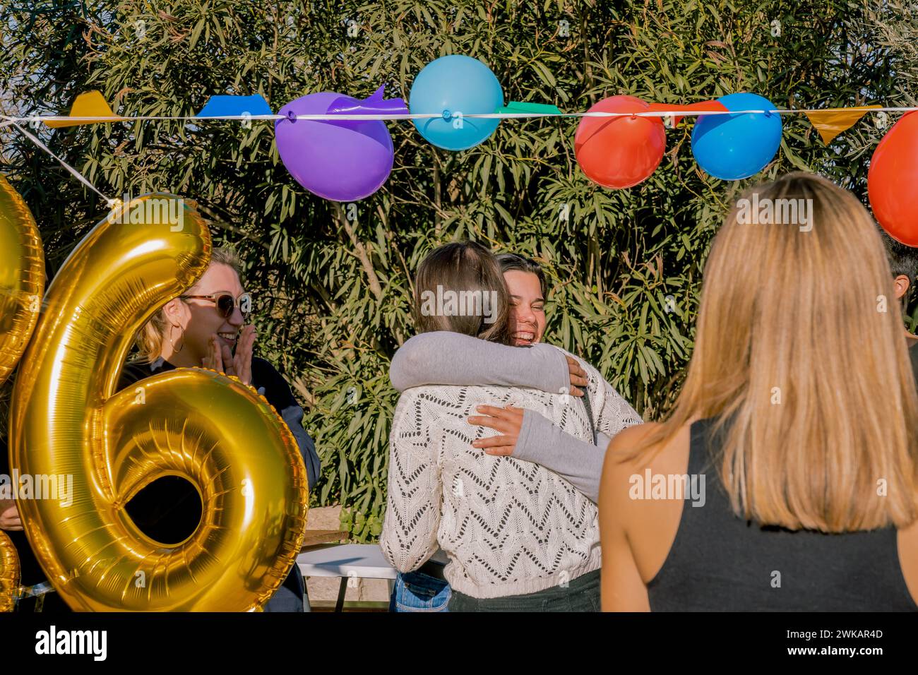 Two friends giving each other a hug during a birthday party after a ...