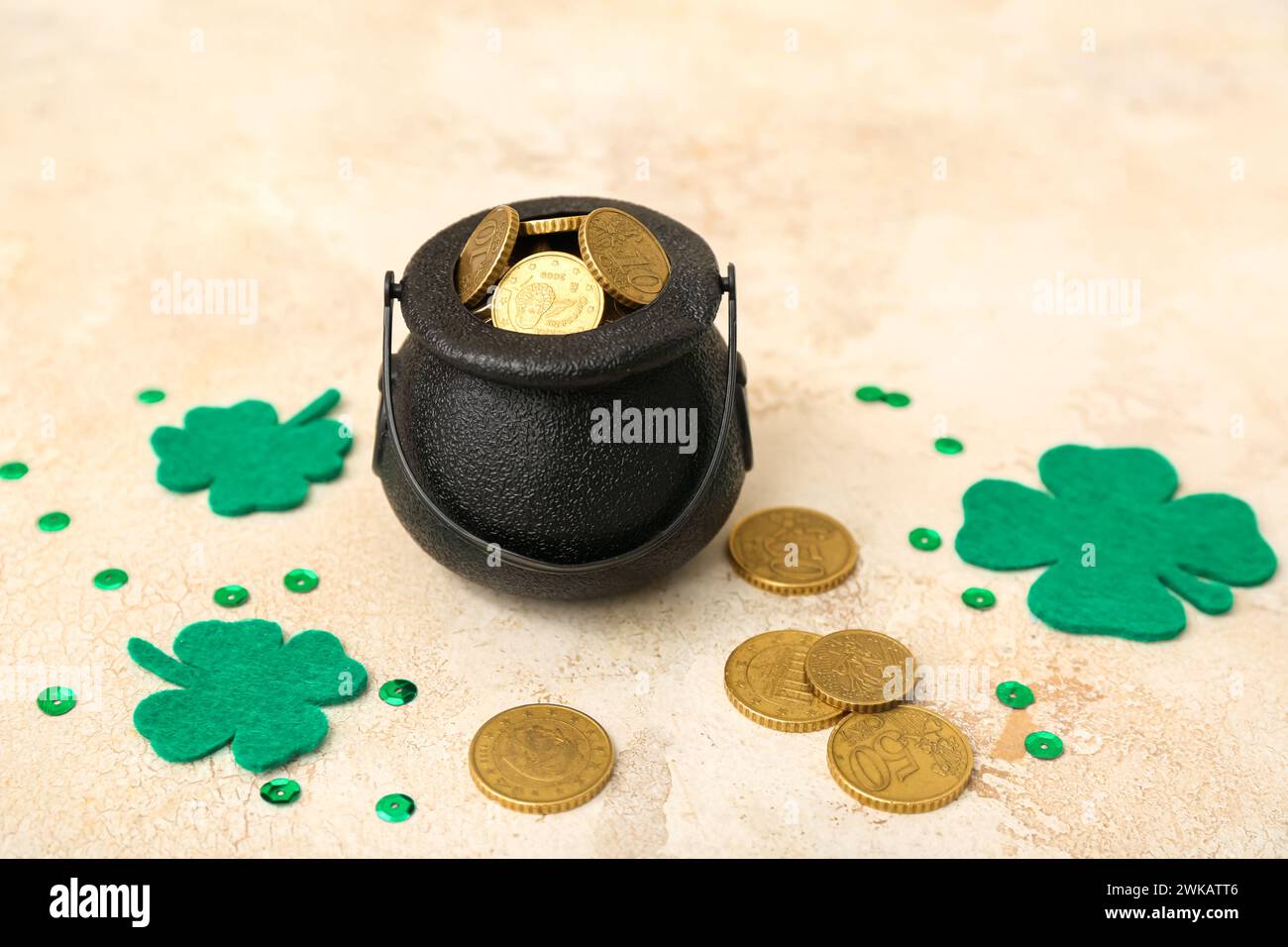 Leprechaun pot with golden coins and clover leaves on beige grunge ...