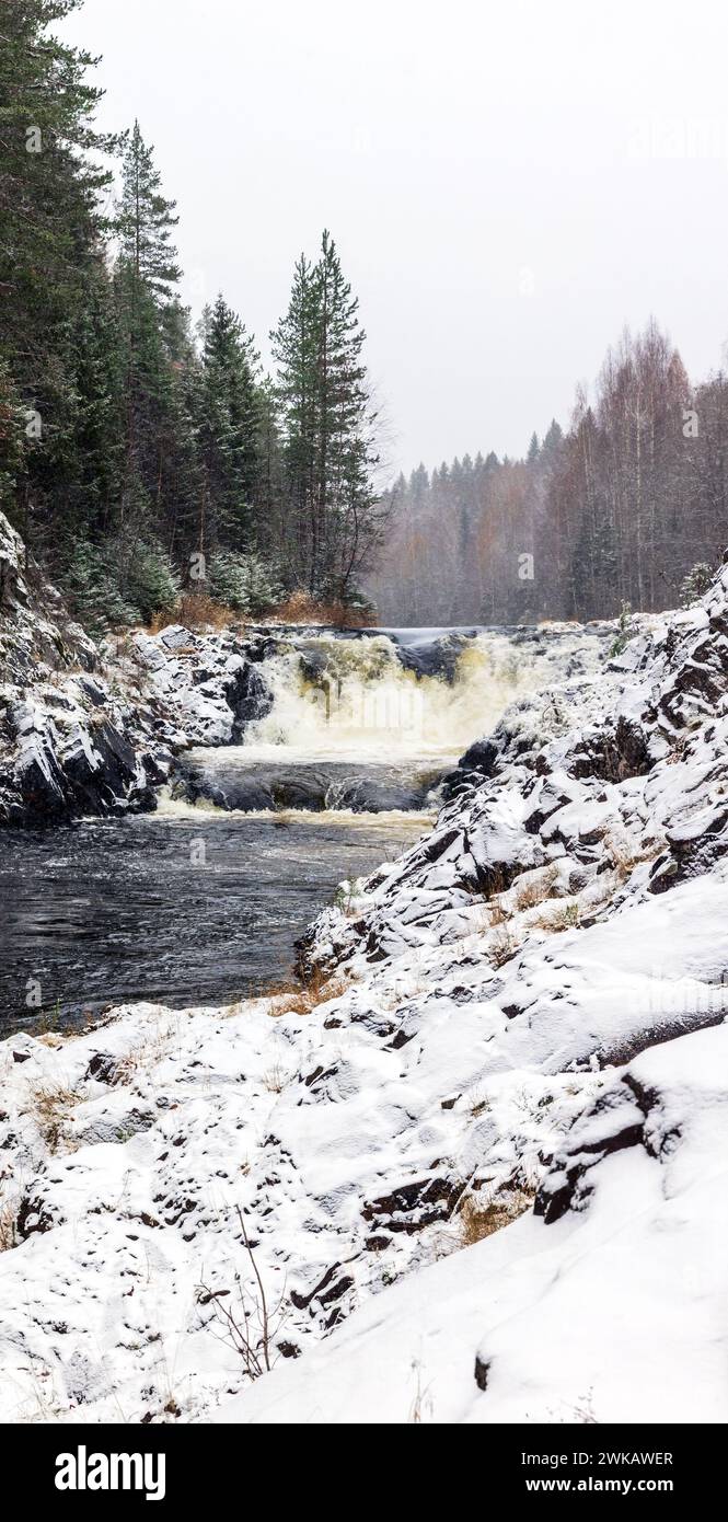 Vertical landscape photo with snowy cascade waterfall. Kivach Falls on ...