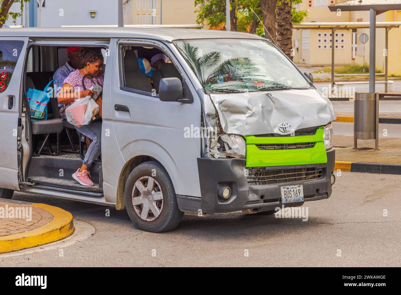 View of minibus taxi with crumpled front end, dropping off passengers ...