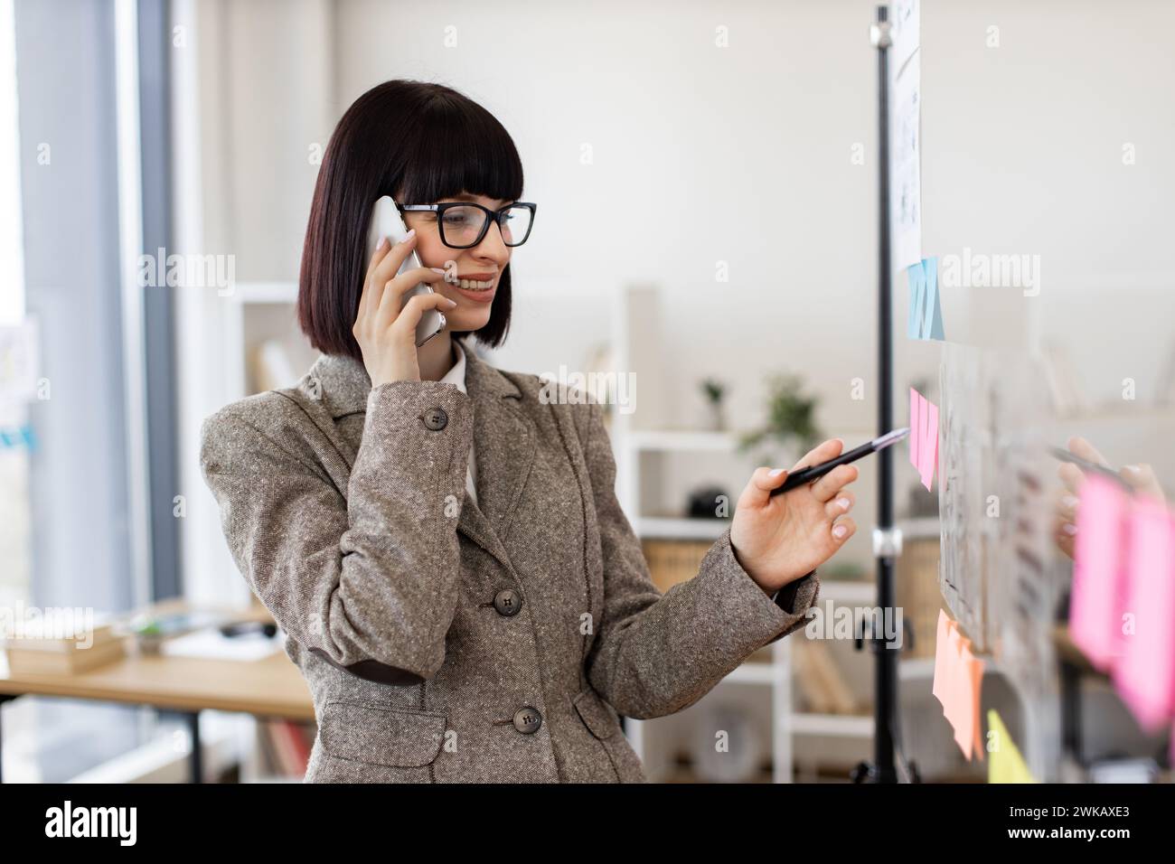 Woman in formal wear and glasses solving business issues having phone ...
