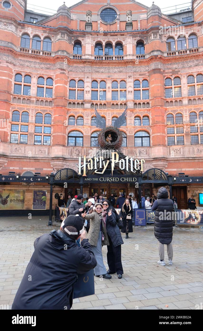 Tourists pose outside the Palace Theatre in the West End of London UK ...