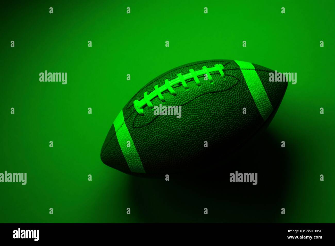 American football ball close up on green background. Horizontal sport ...