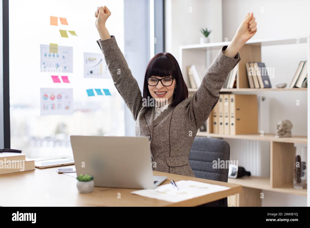 Emotional young lady holding hands high in air while screaming with ...