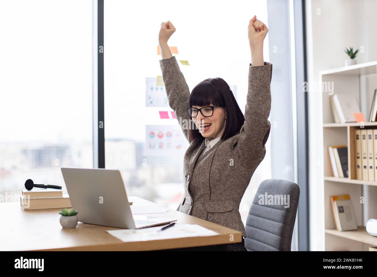 Emotional young lady holding hands high in air while screaming with ...