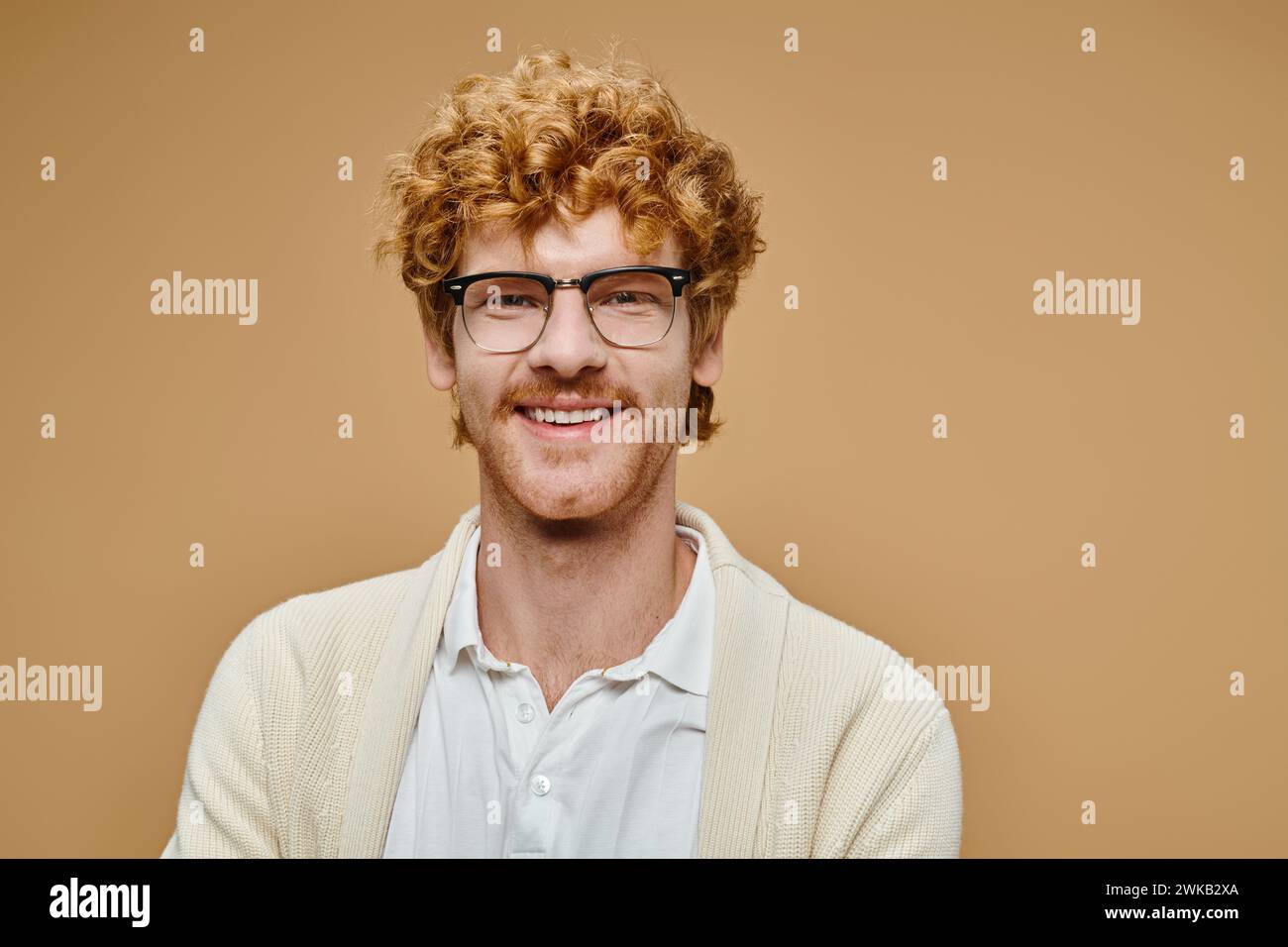 portrait of cheerful redhead man in eyeglasses and trendy light-colored ...