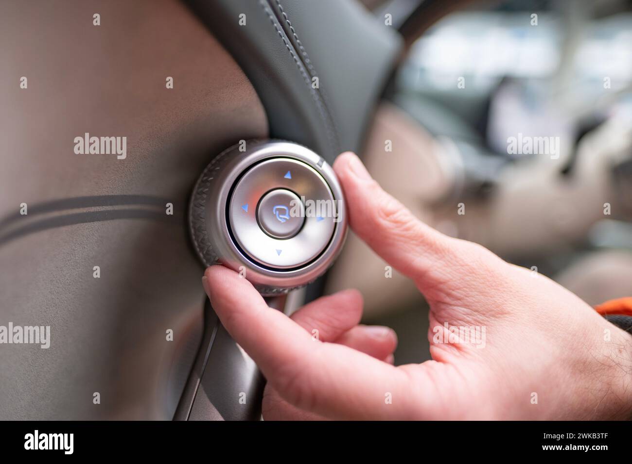 close-up sound system controls on driver's door, Genesis GV60 Electric Car, male hand turns ...