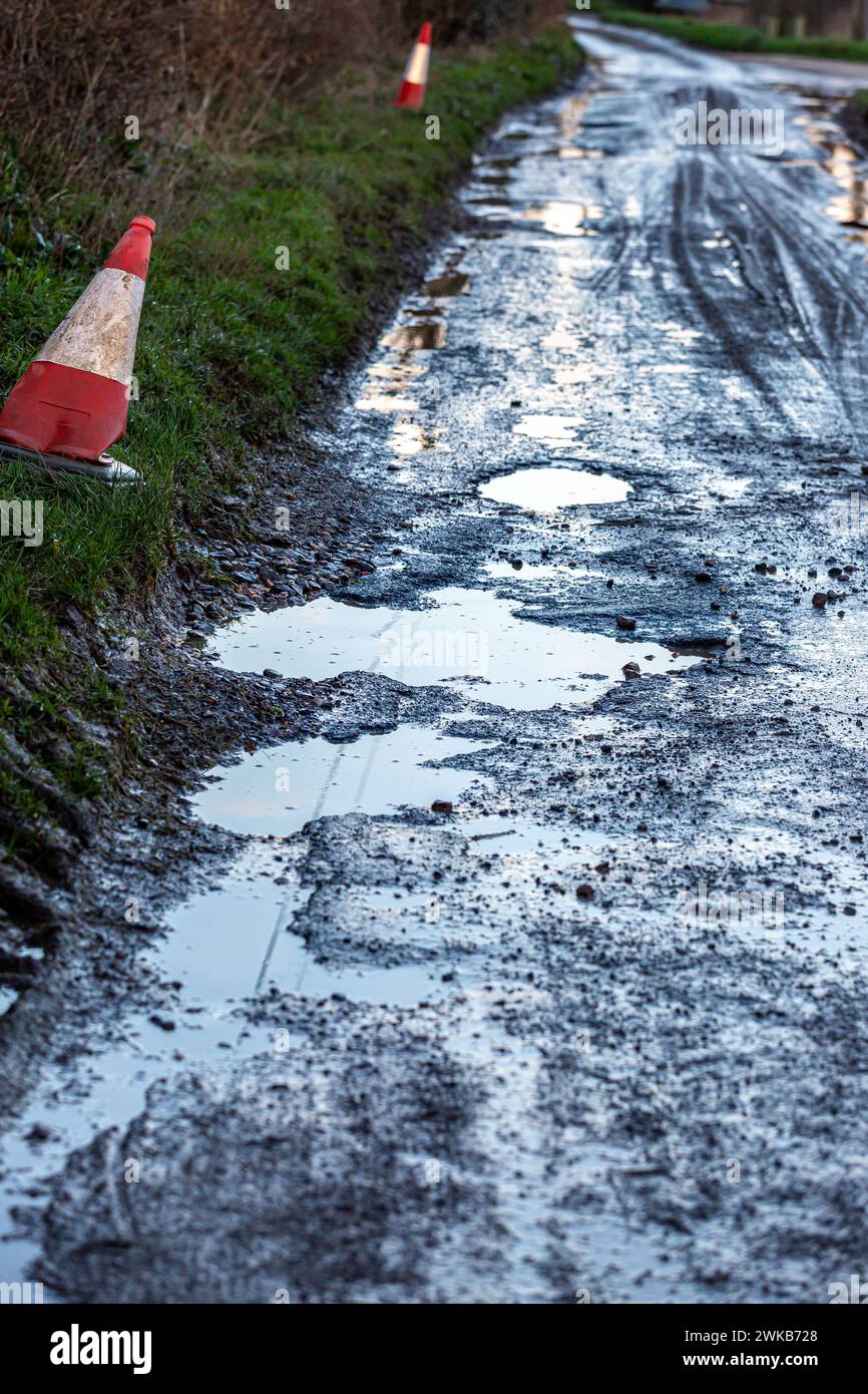Pot holes filled with rain water causing a hazard on a country road in ...