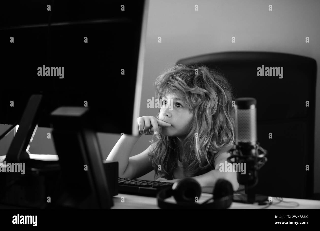 Little child blogger. A pretty child learns a lesson using a desktop ...