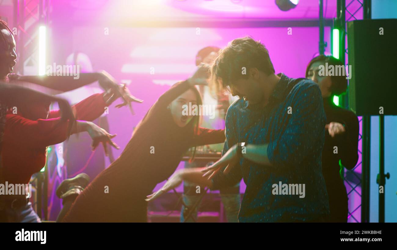 People starting fun dance battle at club, having fun together at party ...