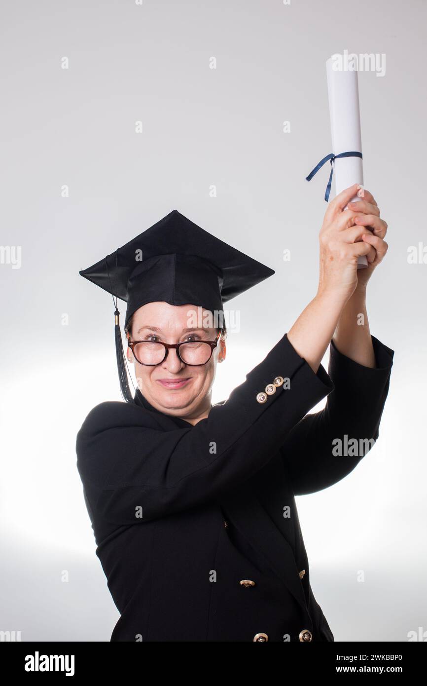 Mature woman with graduation cap showing her certificate. White ...