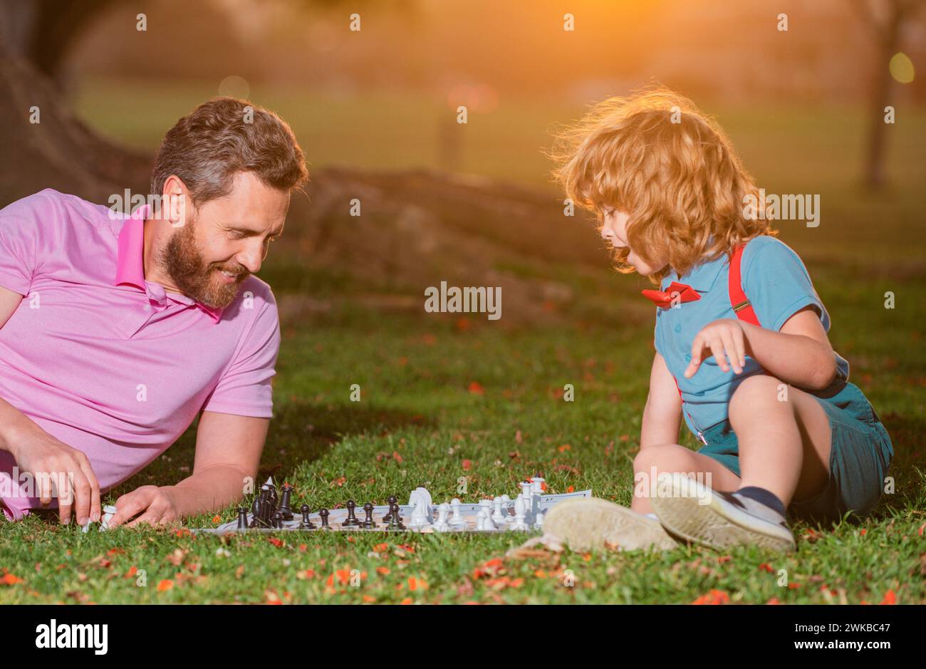 Father and son playing chess spending time together in park. Active ...
