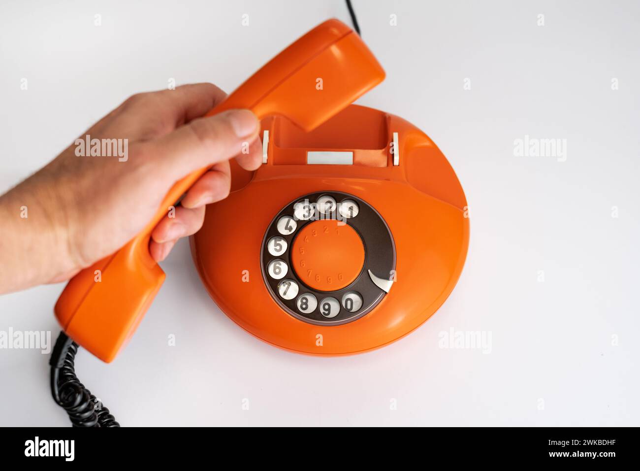 Dialing Using rotary Disk on A vintage Orange color Rotary Phone. Land ...