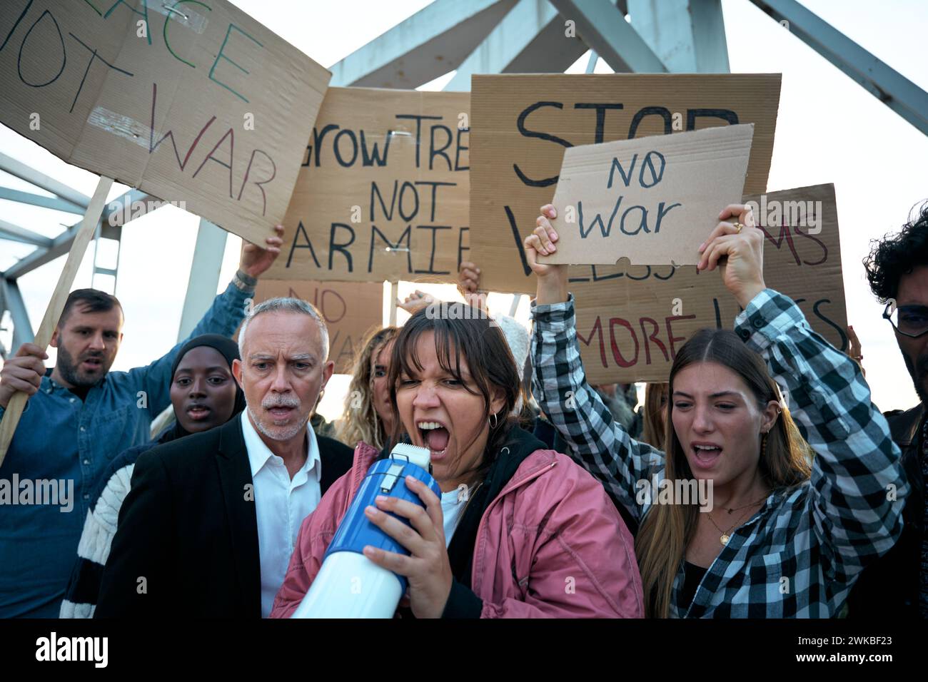 Gen z woman shouting angry with megaphone slogans against wars in world ...
