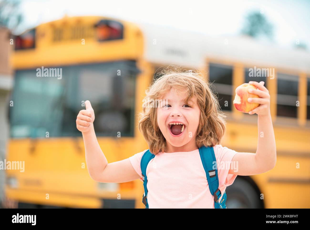 Child getting on school bus. Child with positive gesture with hand ...