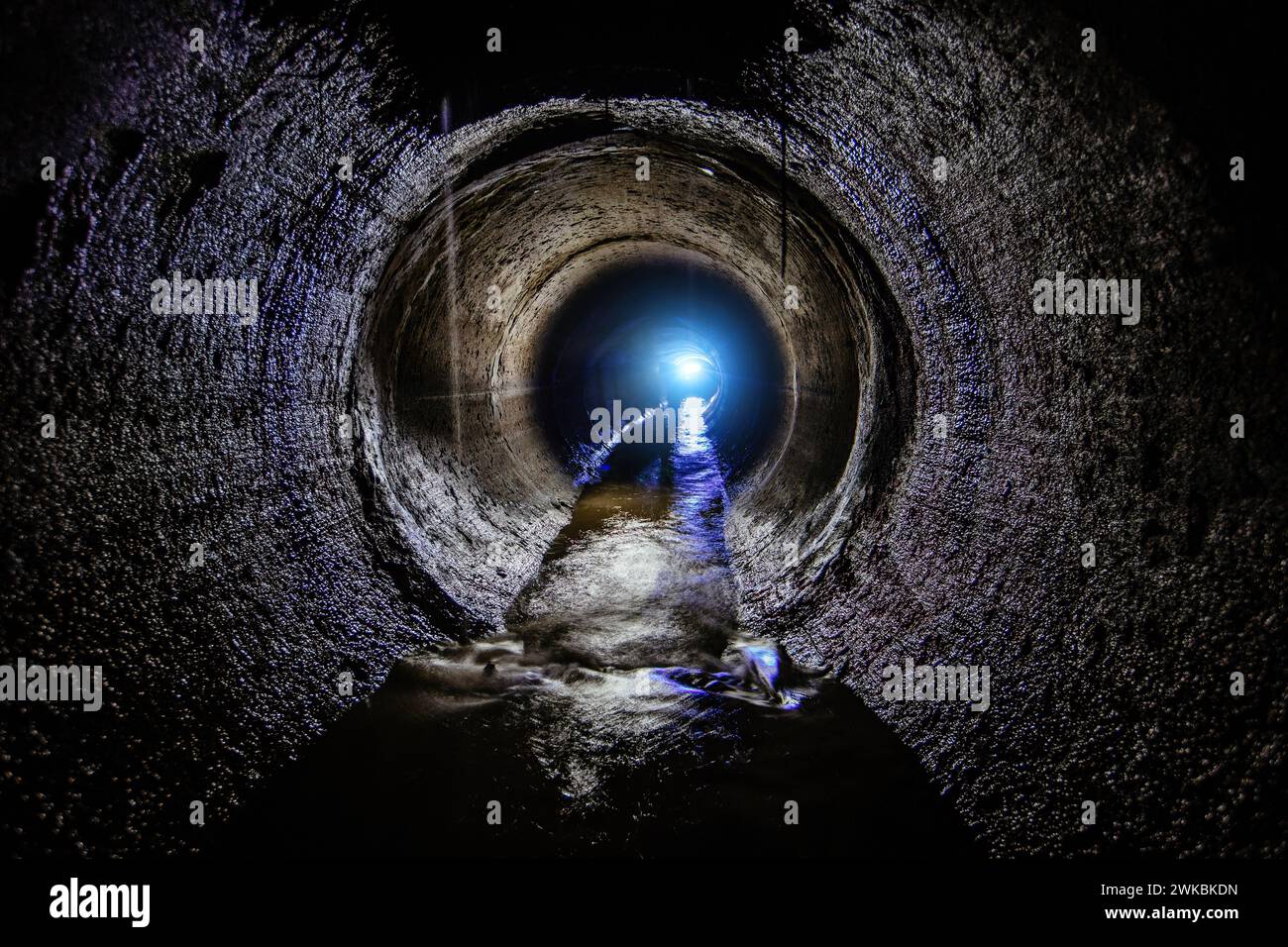 Dirty sewage flowing in round underground sewer tunnel Stock Photo - Alamy