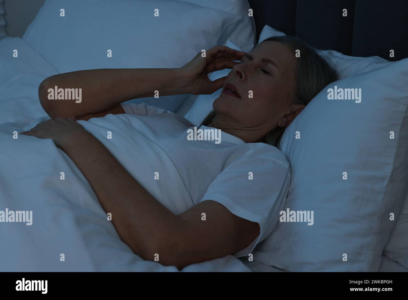Woman suffering from headache in bed at night Stock Photo - Alamy