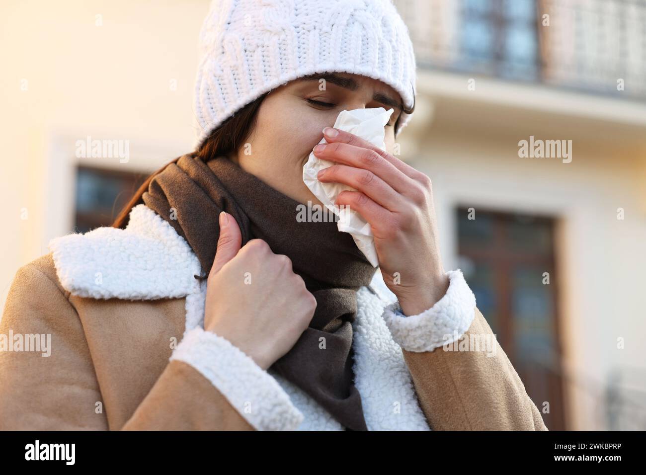 Woman with tissue blowing runny nose outdoors. Cold symptom Stock Photo ...