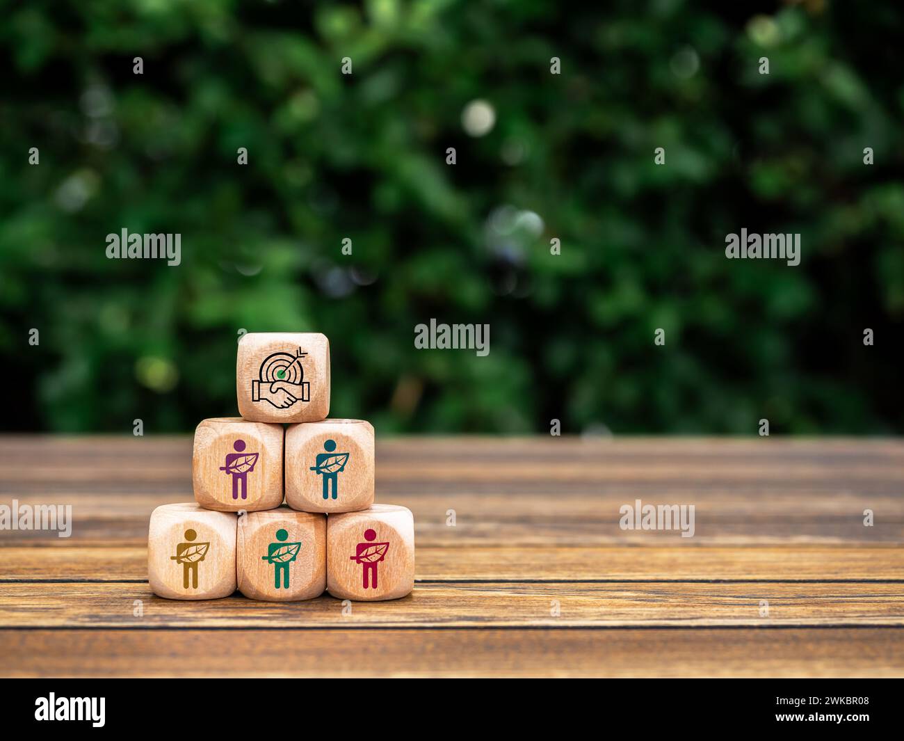 Cooperation icon on top of wood cubes pyramid shape with human holding ...