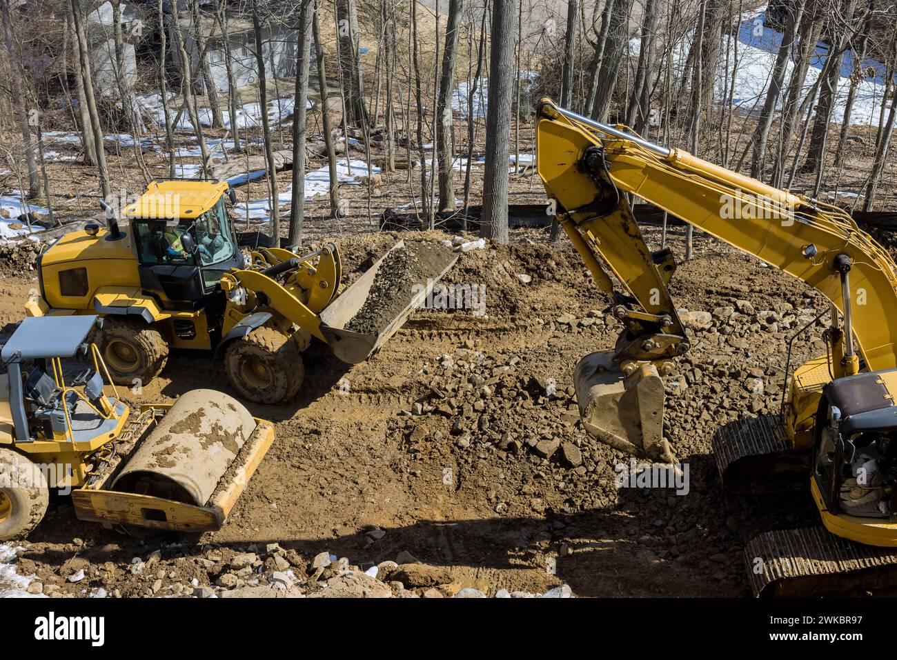Construction excavator digs trenches at construction site during ...