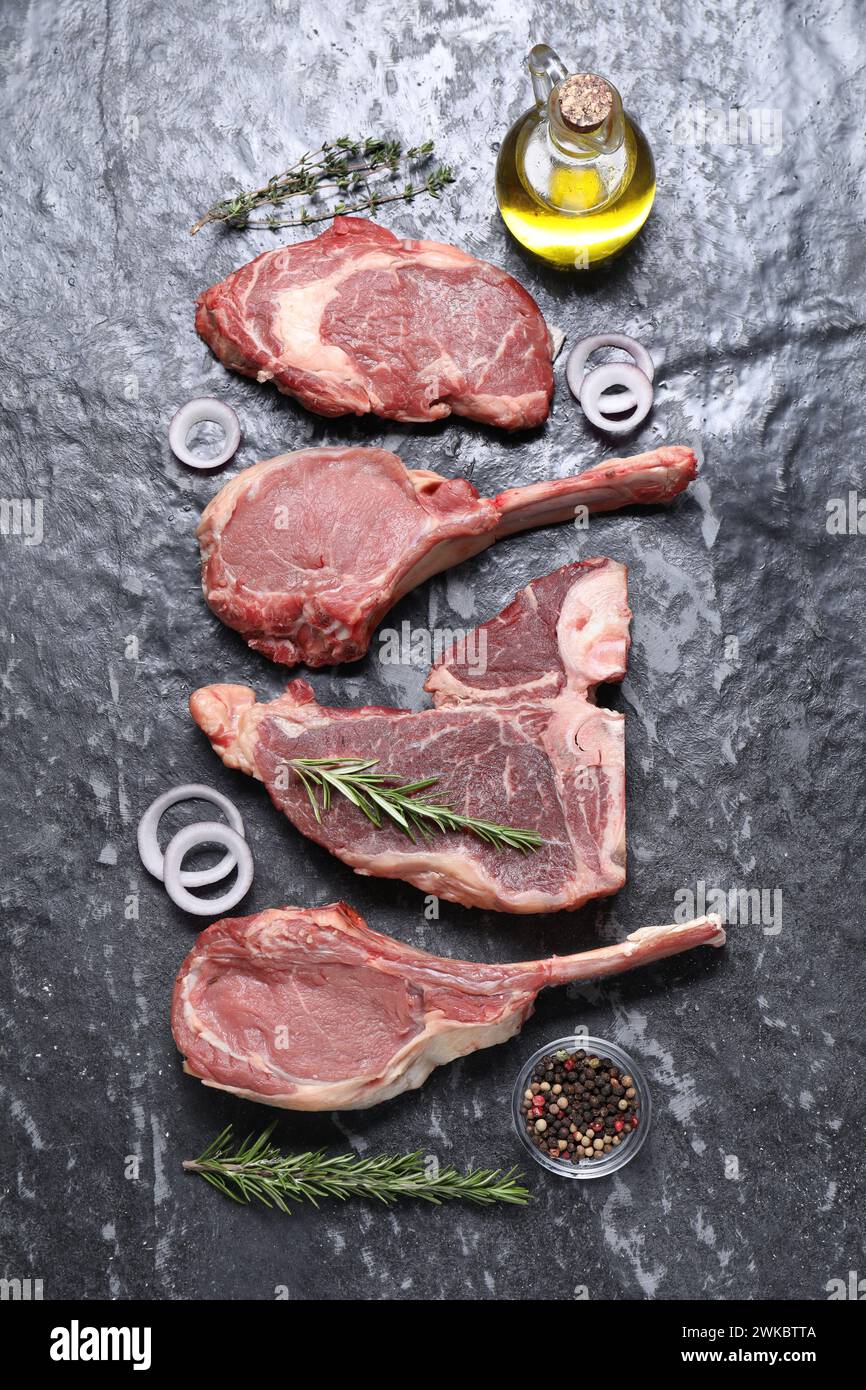 Fresh raw beef cuts and different spices on grey textured table, flat ...