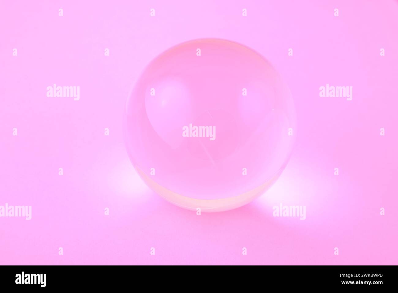 Transparent glass ball on light violet background Stock Photo - Alamy