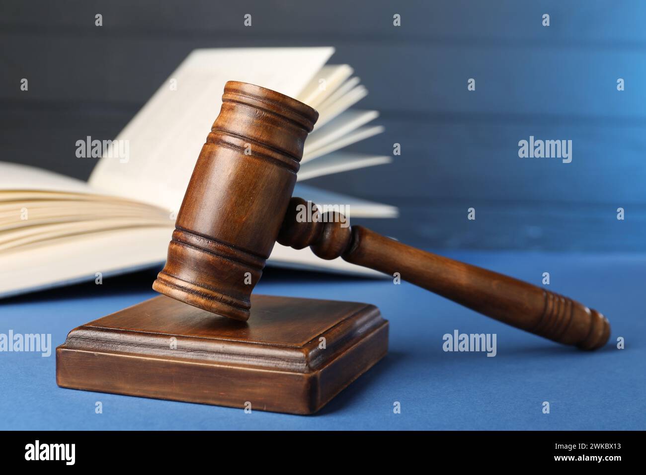 Wooden gavel, sound block and book on blue table, closeup Stock Photo ...