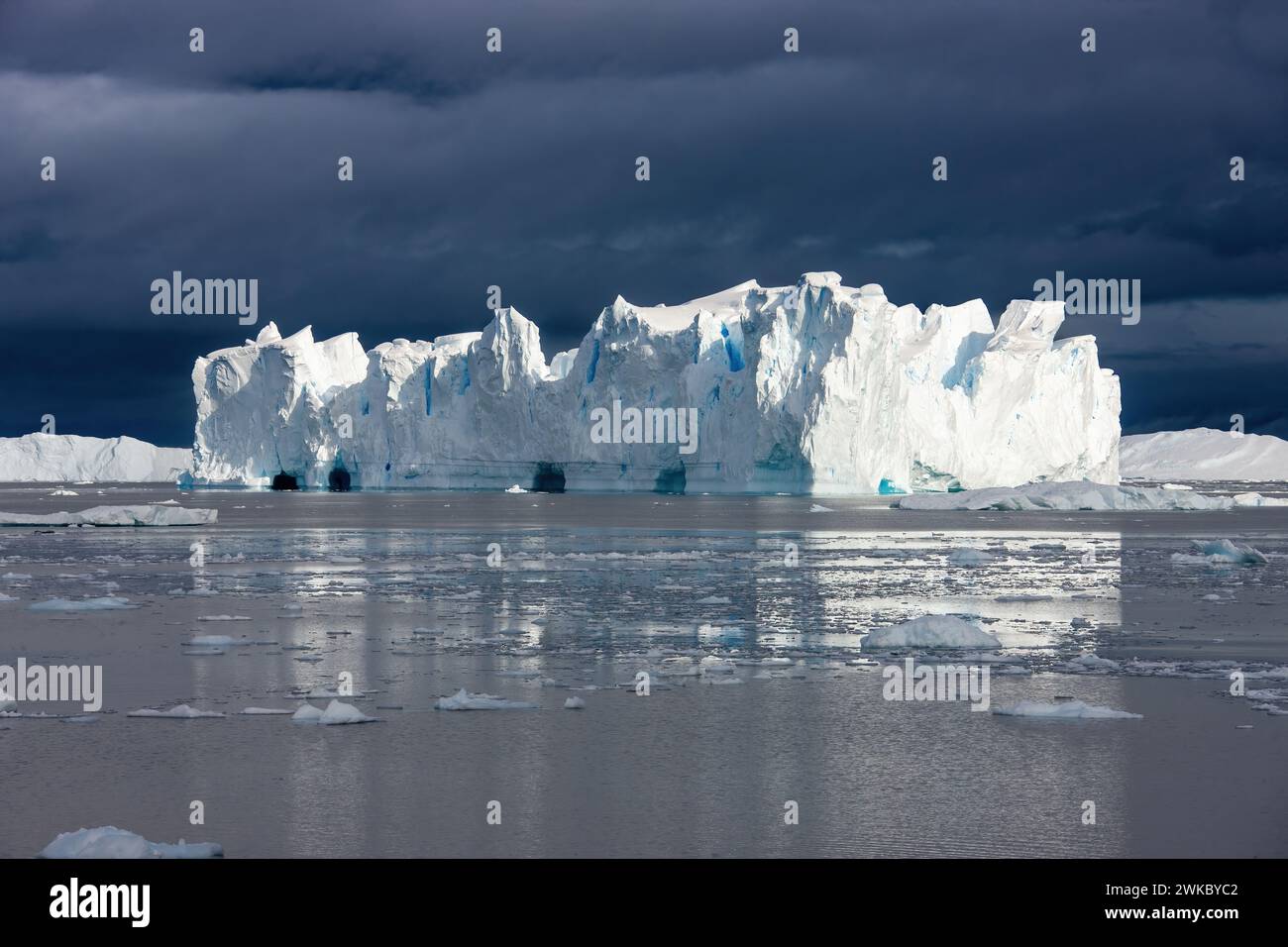 Large iceberg with ice caves broken off from an ice shelf, beneath a ...