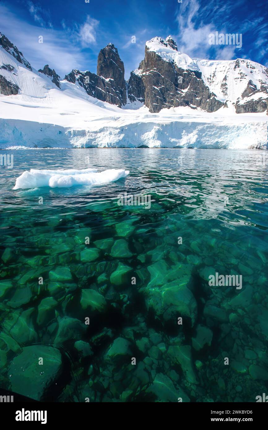 A shallow bay surrounded by towering snow clad peaks on the Antarctic ...