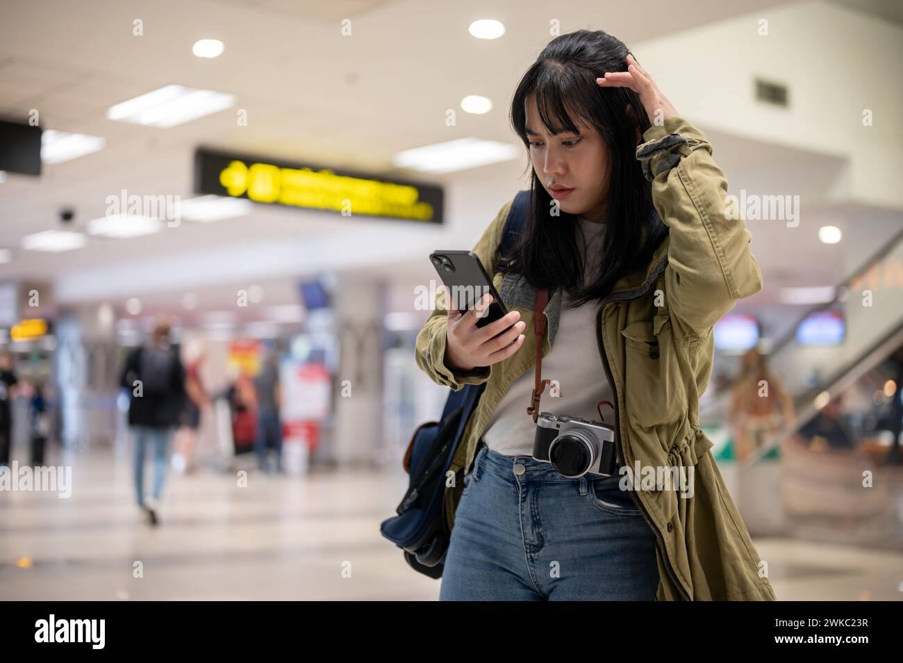 A confused young Asian female solo traveler is reading her flight ...